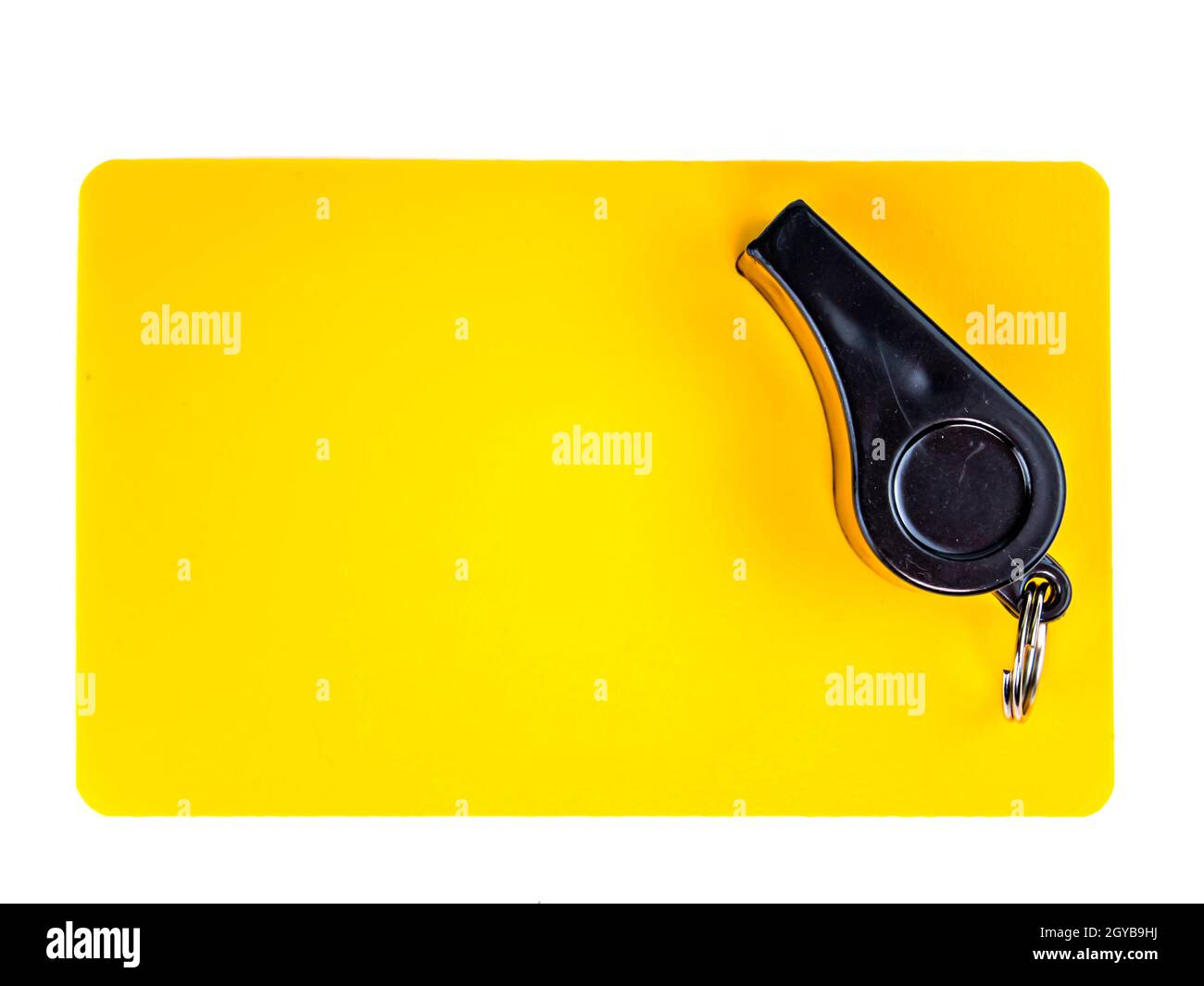 Yellow card and whistle of a football referee on a white background ...