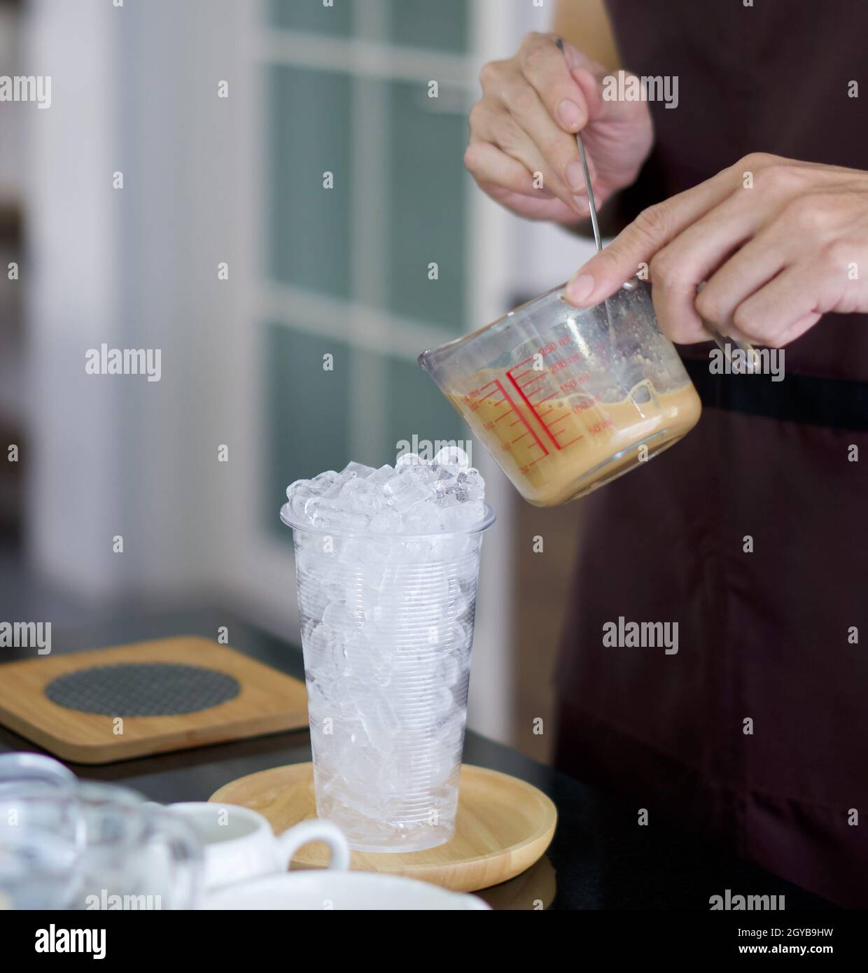 Clear plastic cup with ice for iced coffee on the table. Professional ...