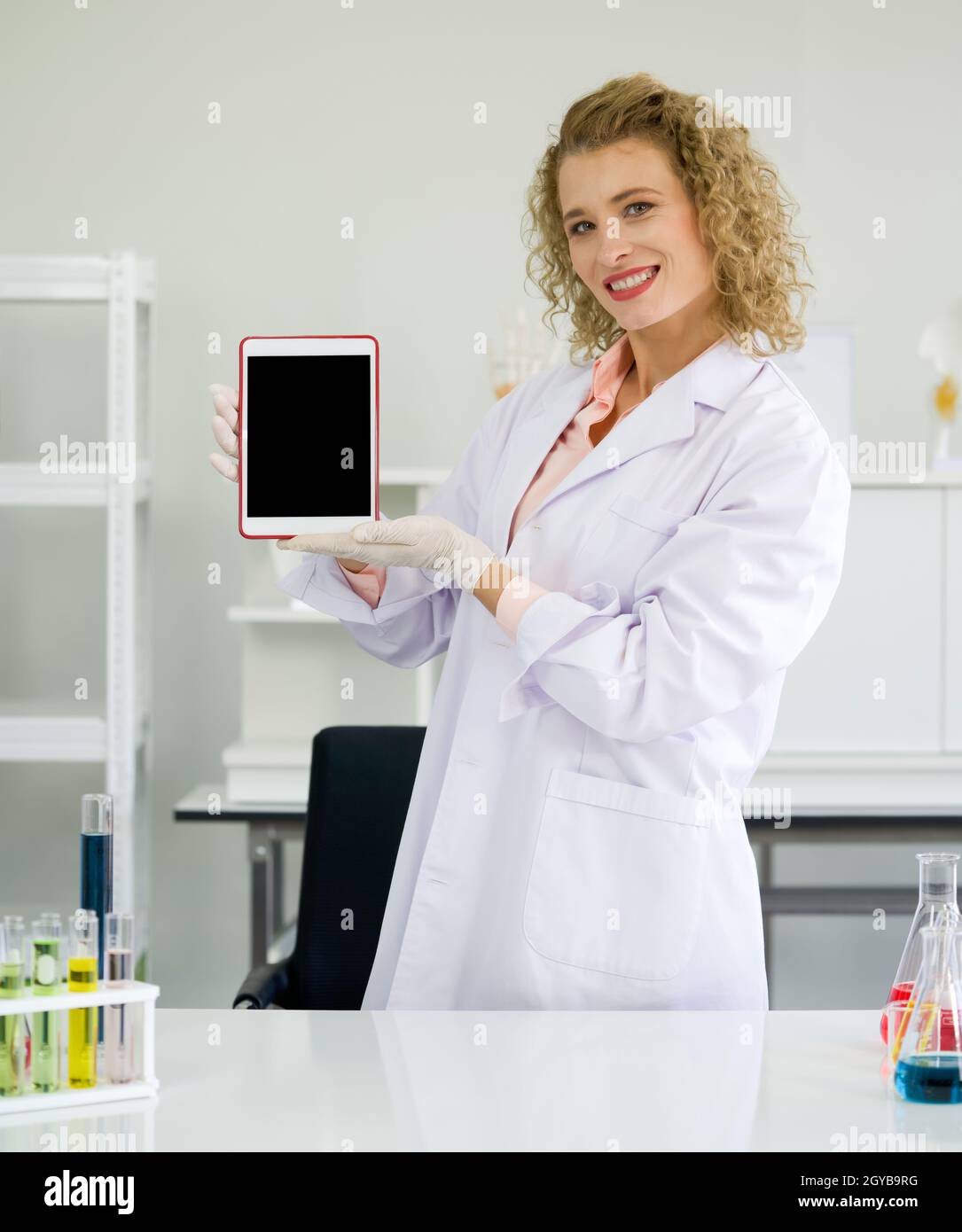 Young blonde scientist holding blank screen tablet computer. Working ...