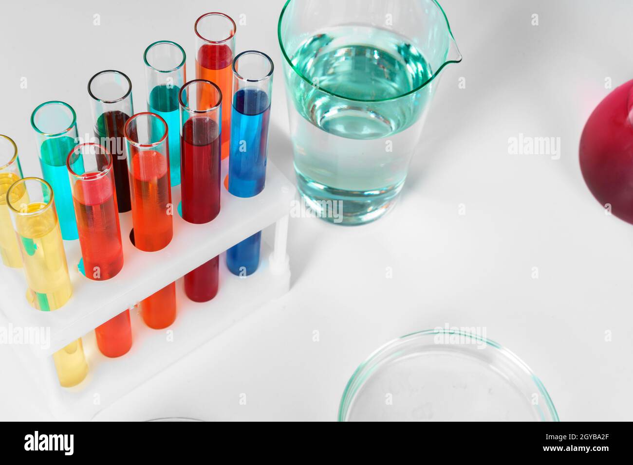 Chemical laboratory glassware with various colored liquids on table ...
