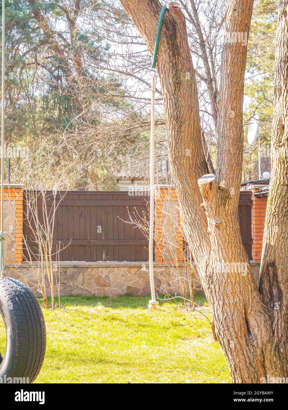 The rope is tied to a tree branch in the playground. Outdoor sports ...