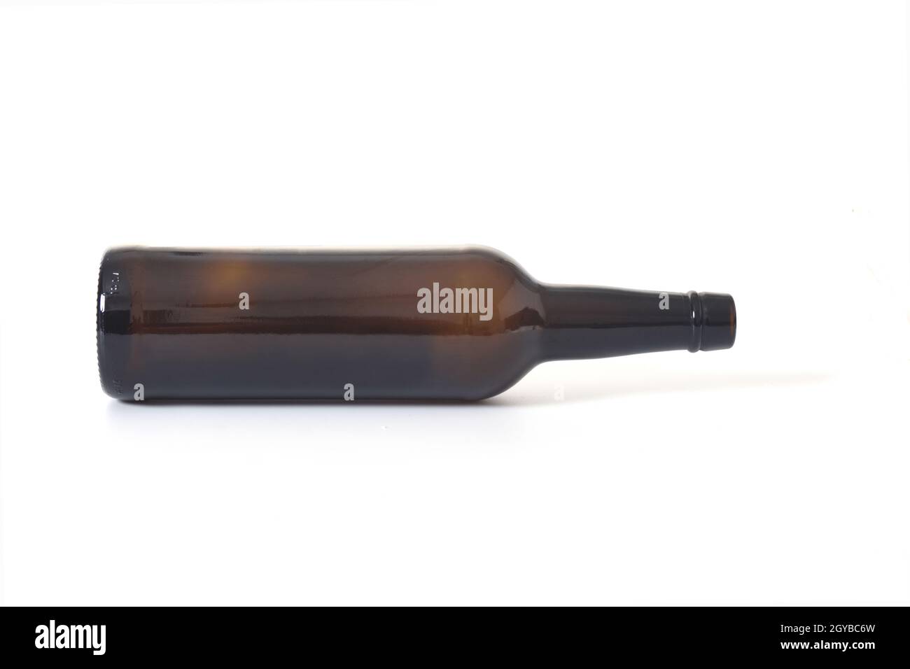 brown glass alcohol bottle lying on white background Stock Photo - Alamy