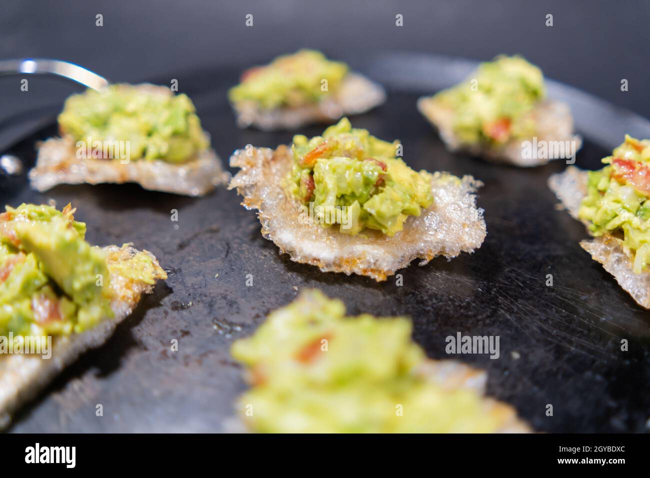 Pork rinds with guacamole on traditional Mexican comal Stock Photo - Alamy