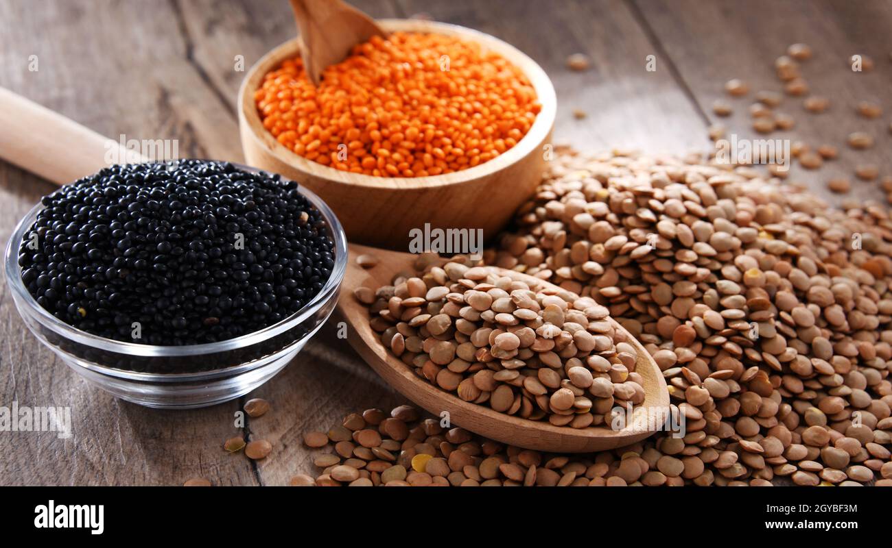 Composition with three sorts of lentils on wooden table Stock Photo - Alamy