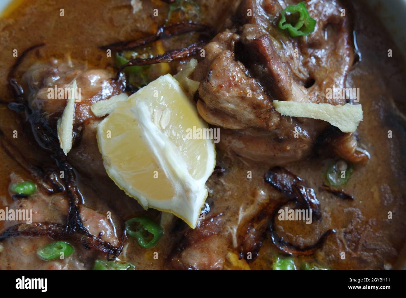 Closeup view of traditional Pakistani Haleem dish with salad and Lemon ...