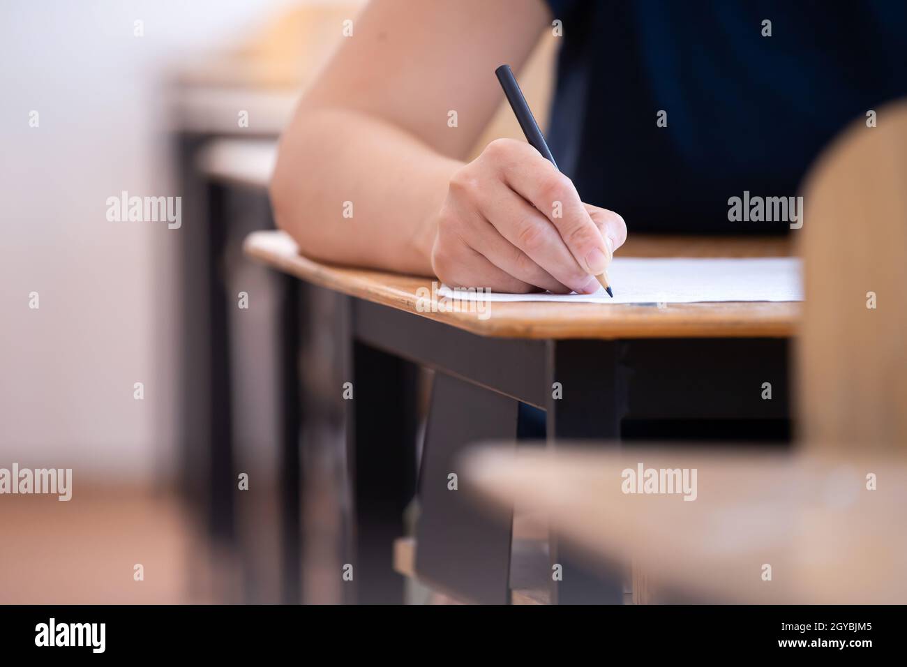 High school or university student holding pencil writing on paper ...