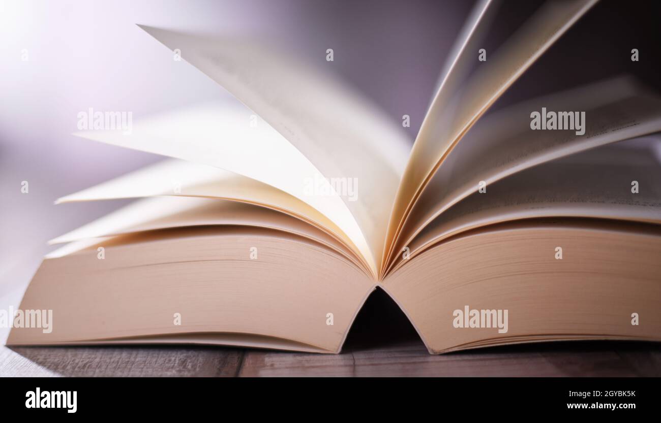 Composition with open book on the table Stock Photo - Alamy