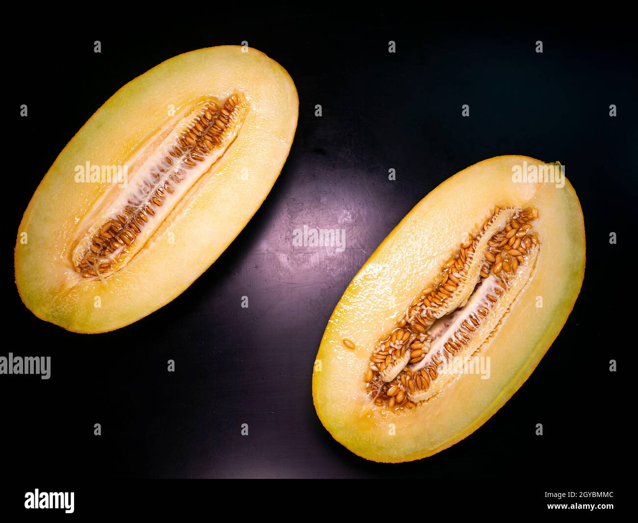 Yellow melon cut with a knife on a black background. Food photo. Melon ...