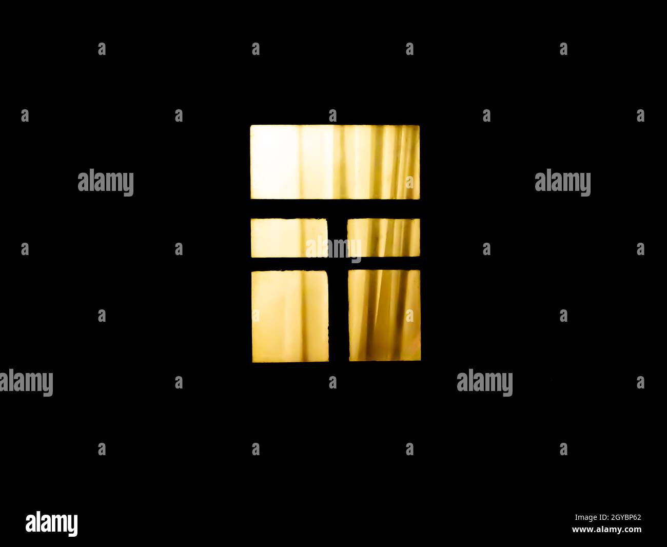 The window of the house glows in the dark at night. Electric light at ...