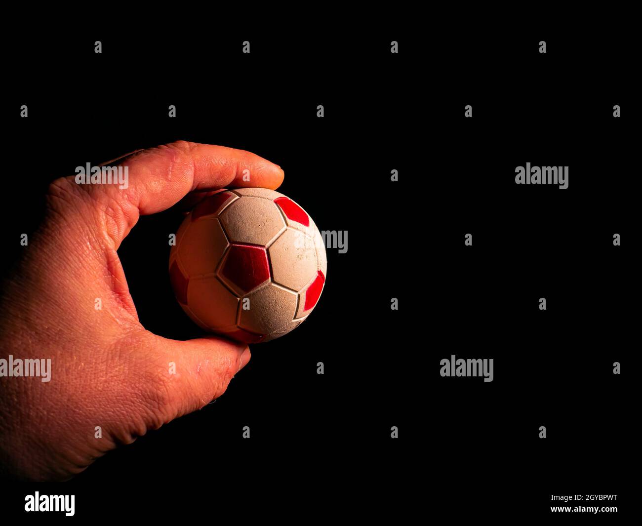 Soccer ball in hand on a black background. Soccer ball. Palms of human ...