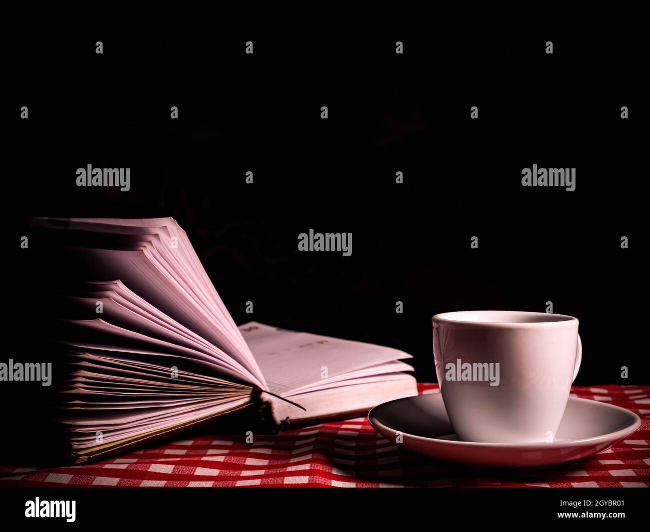 A coffee cup with a saucer and a notebook on the table. Ceramic cup ...