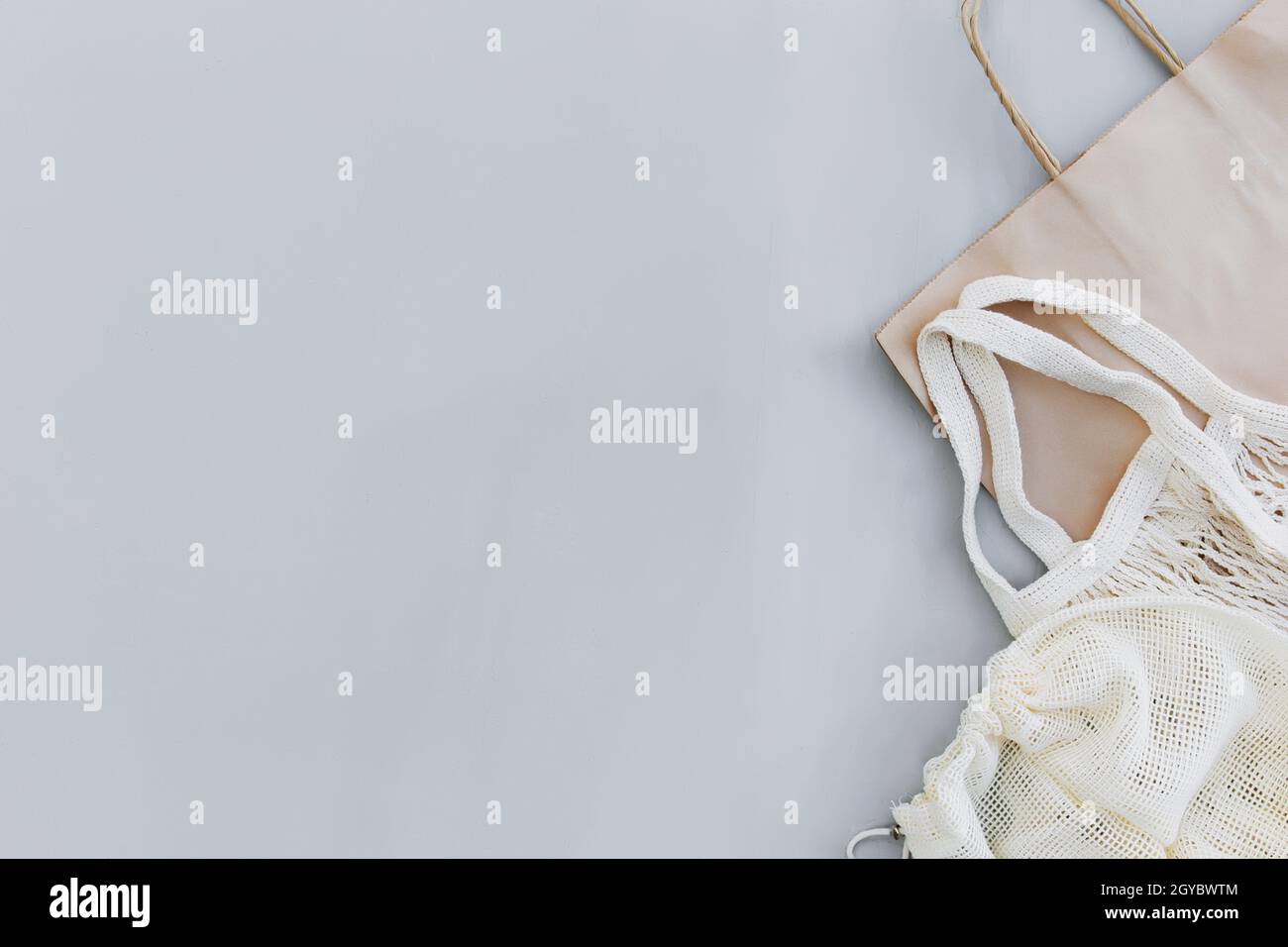 Flat lay with eco white craft paper bags and net bags on gray ...