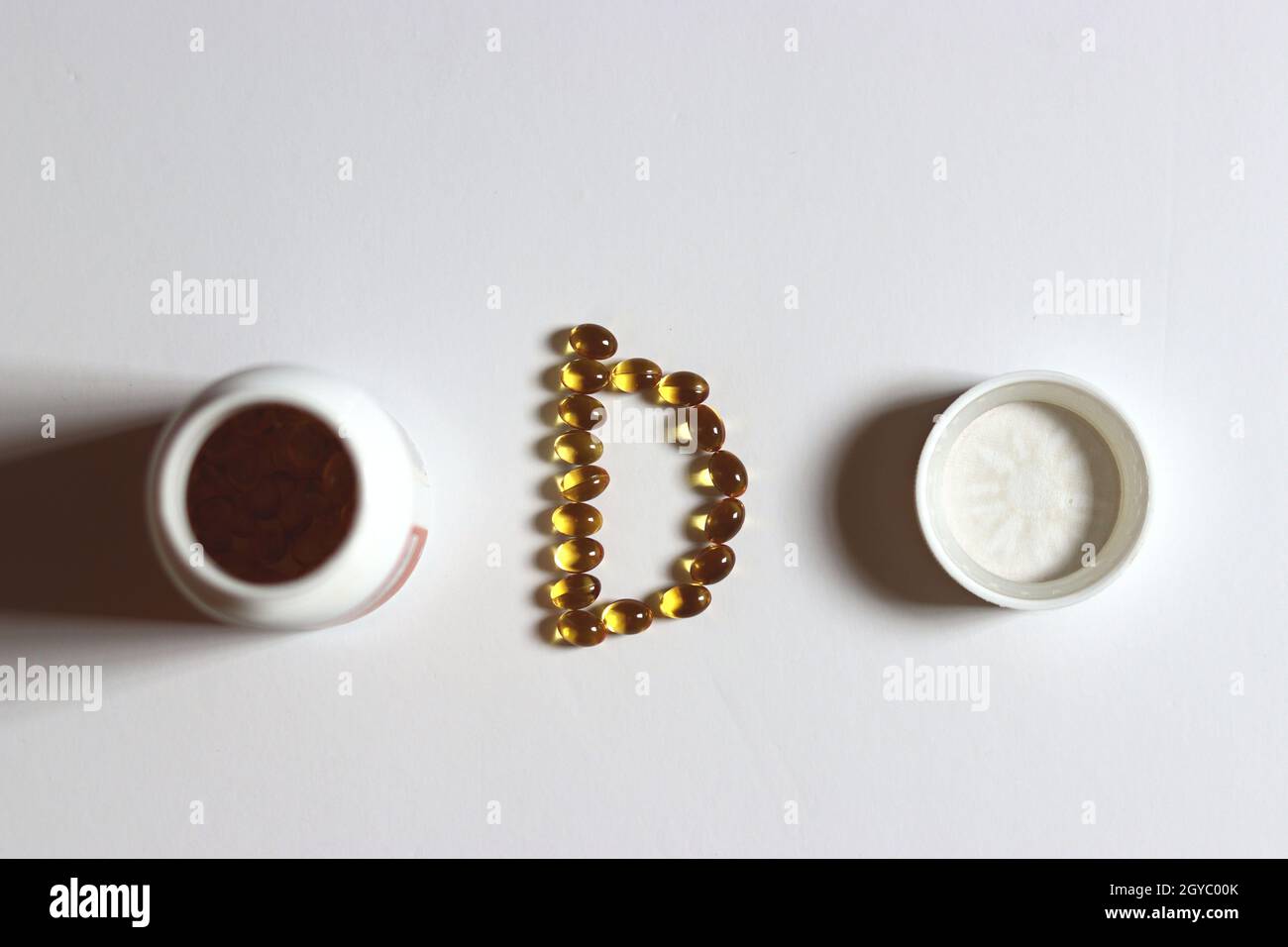 Vitamin D bottle with capsules forming the letter "D" isolated on a ...