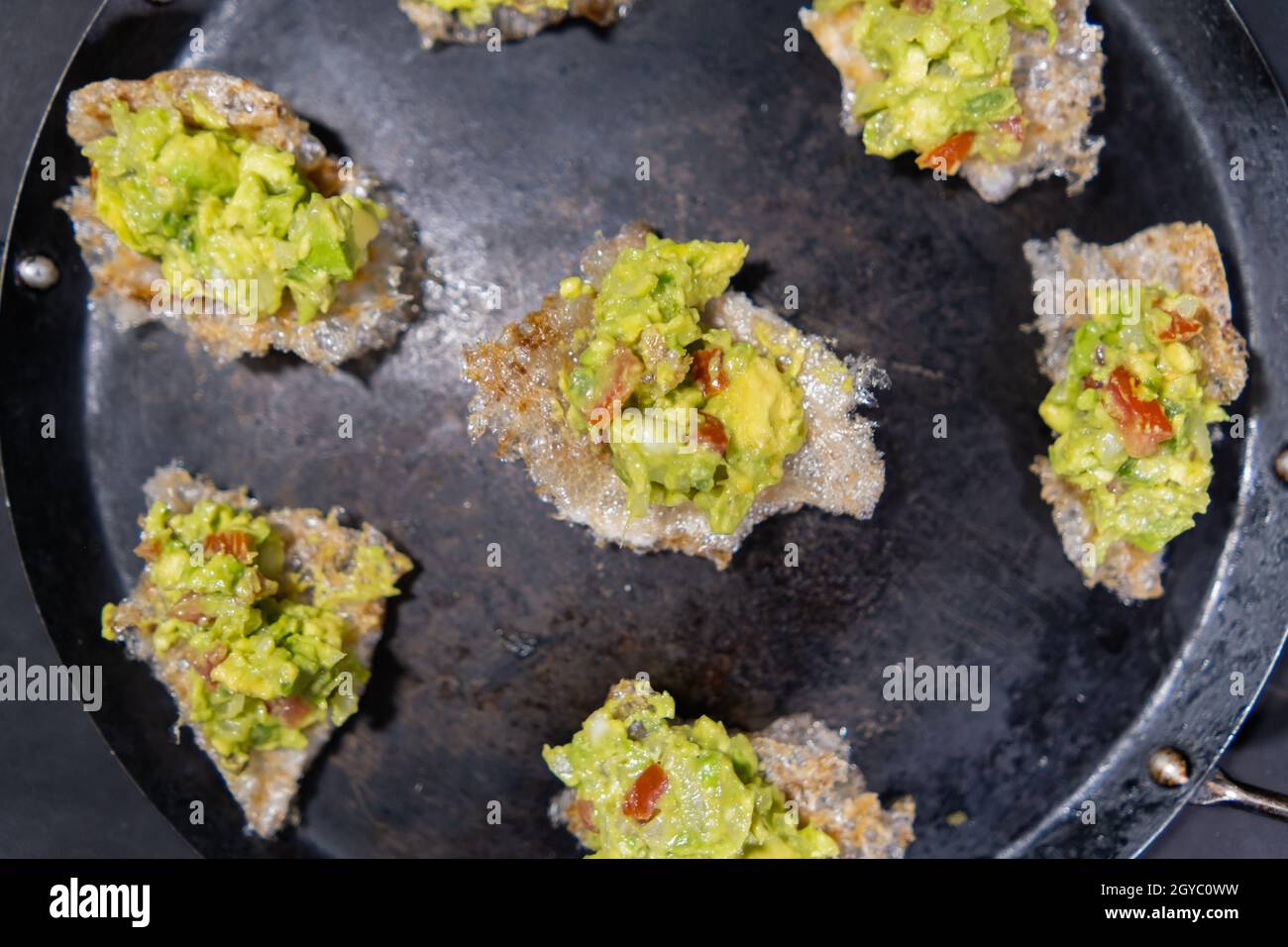 Pork rinds with guacamole on traditional Mexican comal Stock Photo - Alamy