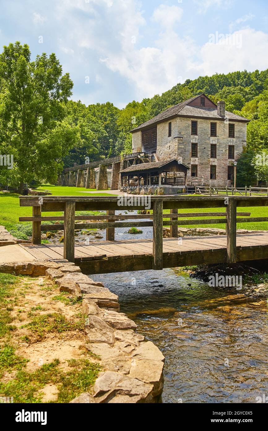Old Stone Mill with wooden walking bridge over tiny creek Stock Photo ...