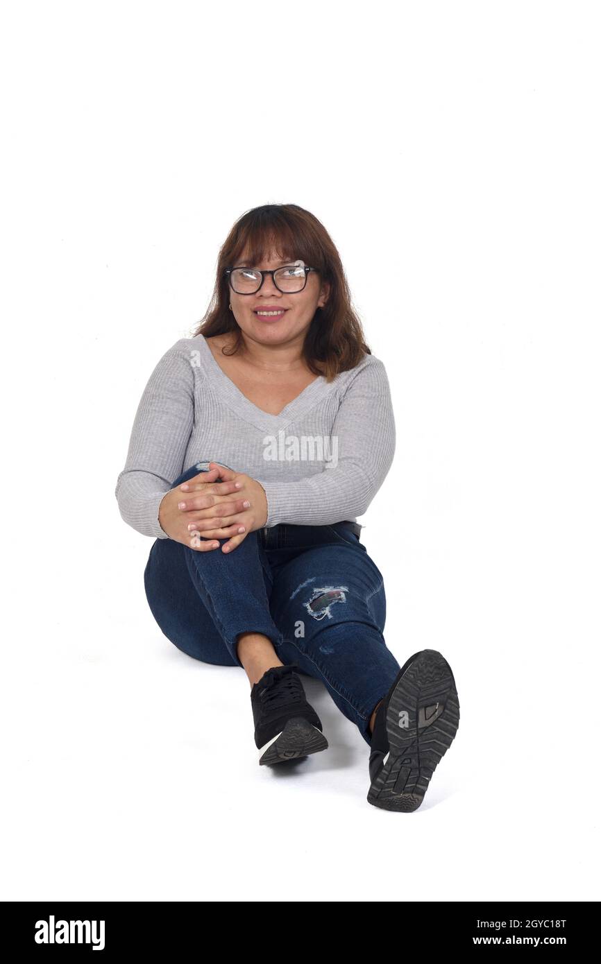 front view of woman sitting on the floor, looking at camera and with ...