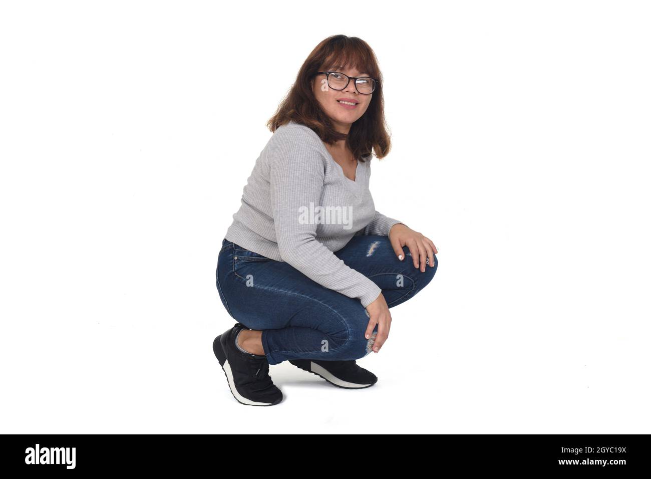 woman squatting and looking at camera on white background Stock Photo ...