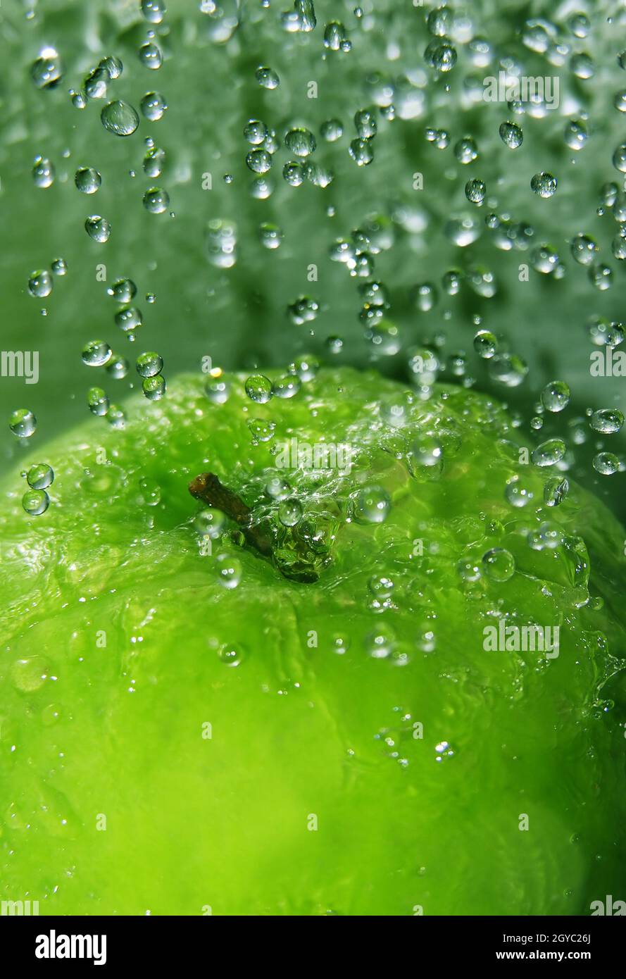 Water drops falling onto a green apple Stock Photo - Alamy