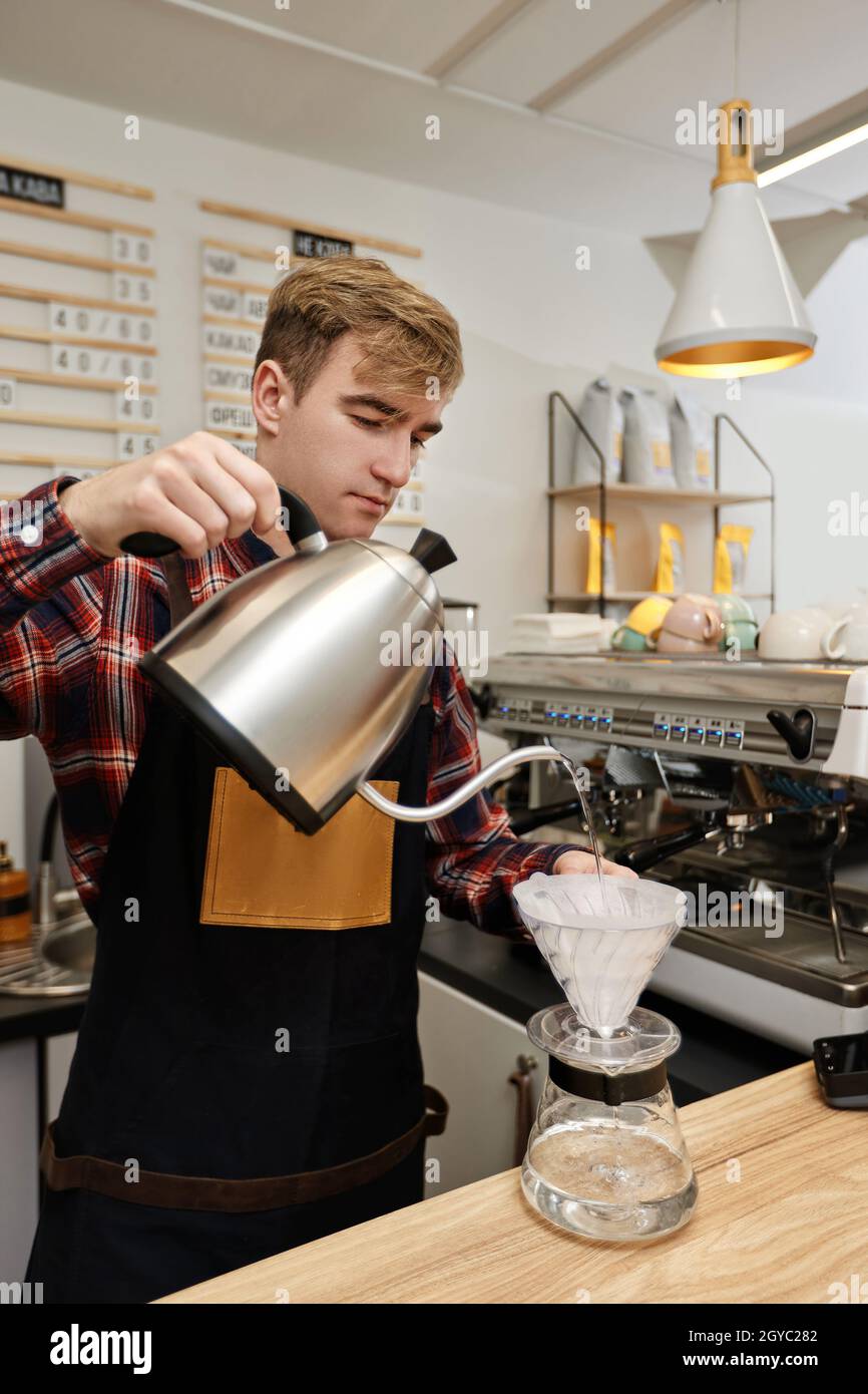 Professional barista man making coffee using filter and kettle at the ...
