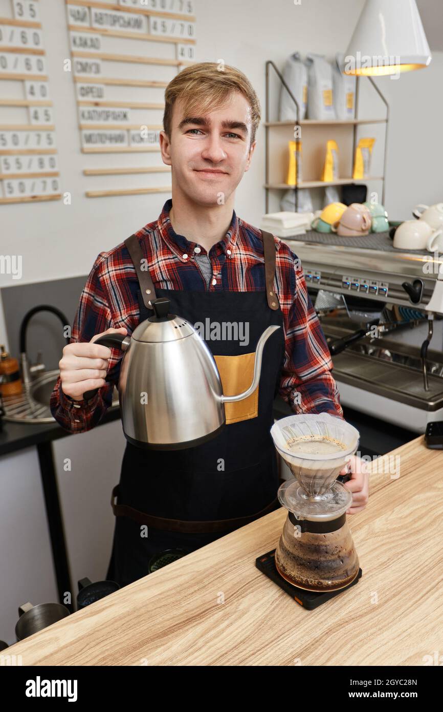 Professional barista man making coffee using filter and kettle at the ...