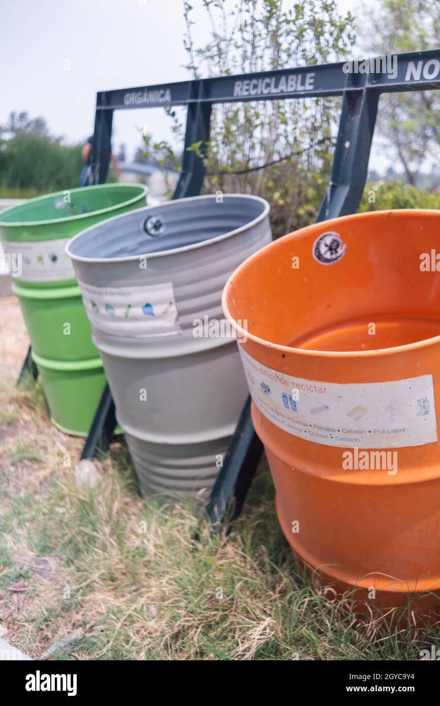 Spanish signs above colorful trash cans in park Stock Photo - Alamy