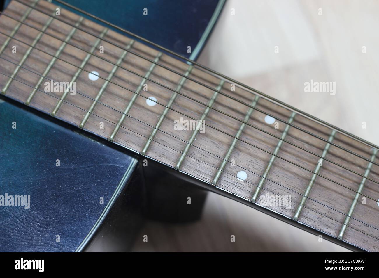 Closeup of an acoustic guitar with strings on a wooden floor Stock ...
