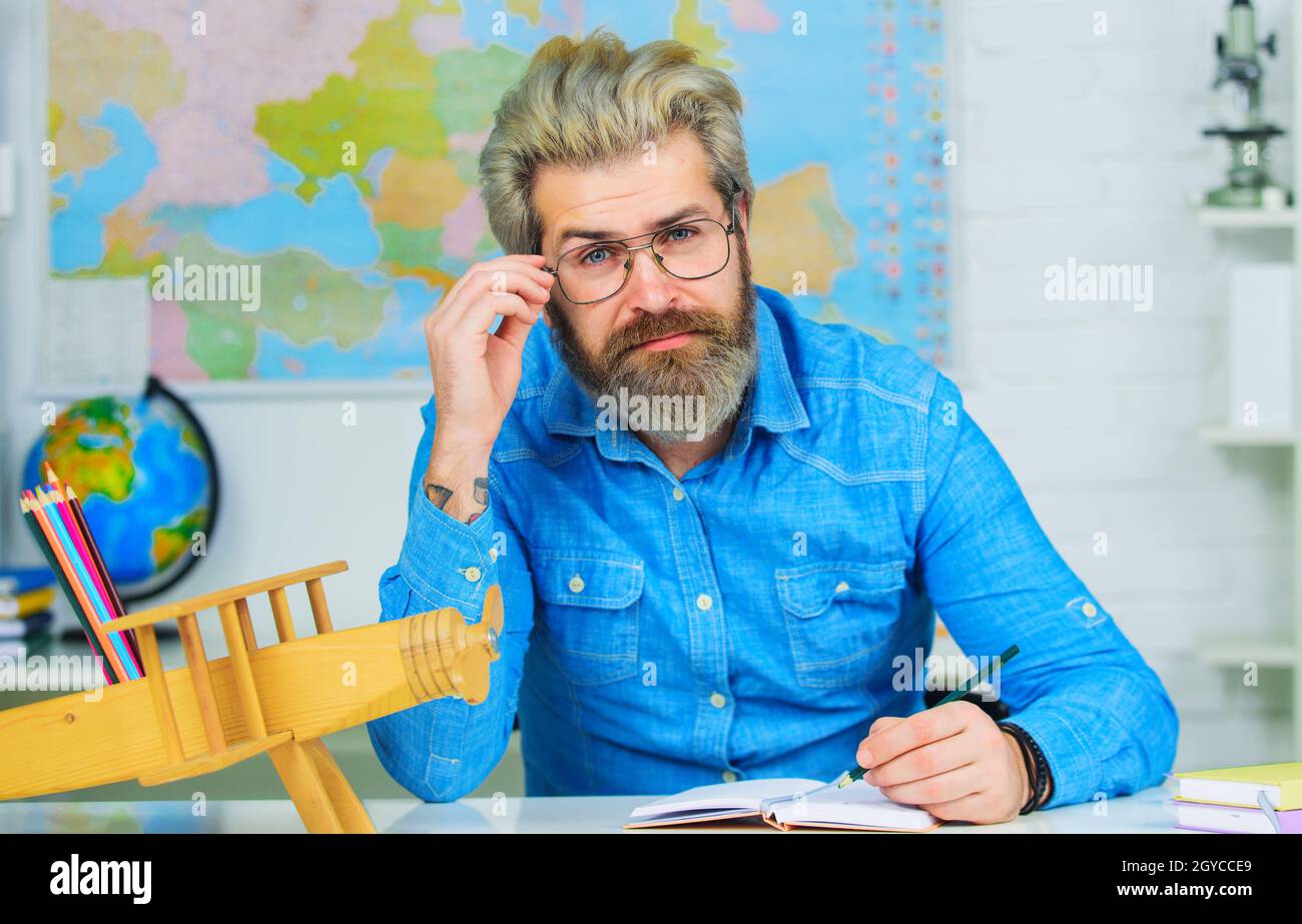 Male Teacher prepares lessons in classroom. Learning, education, school ...
