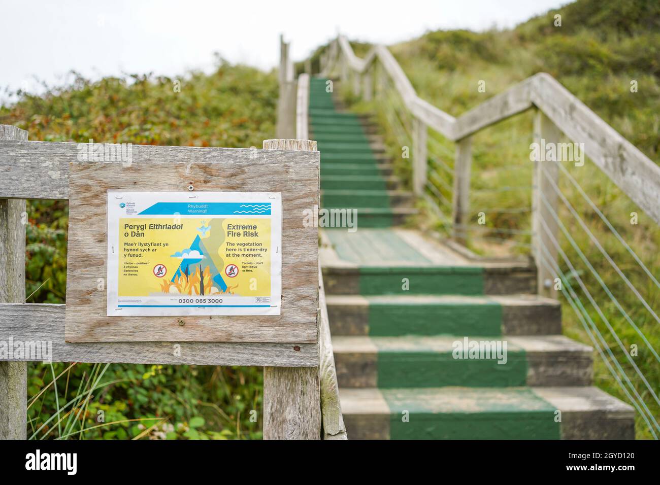 Welsh fire risk sign on a boardwalk heading to a beach Stock Photo - Alamy