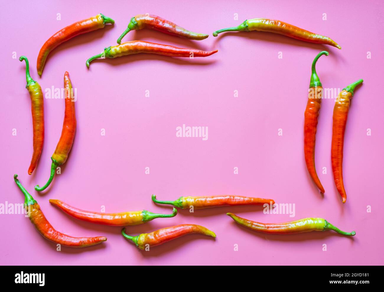 Frame from red, hot, chilli peppers on pink background Stock Photo - Alamy