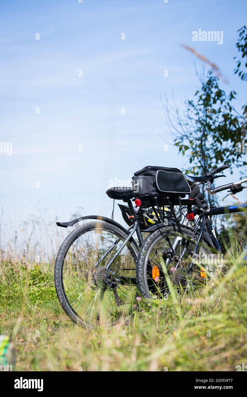 Bike tour: Bikes, grass and blue sky. Outdoors, text space Stock Photo - Alamy