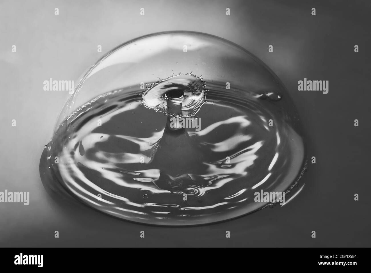 Black and white of pristine bubble containing ripples from two water ...