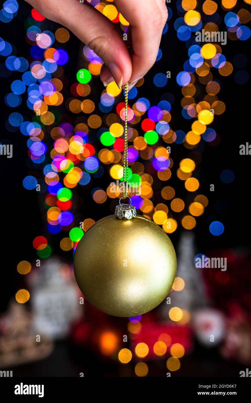 Holding Christmas decoration against bokeh lights background Stock Photo - Alamy