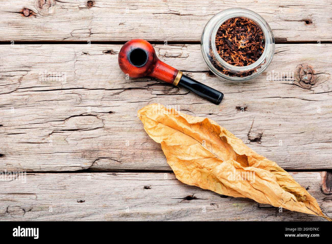 Tobacco pipe, tobacco leaf and pipe tobacco.Smoking pipe on rustic ...
