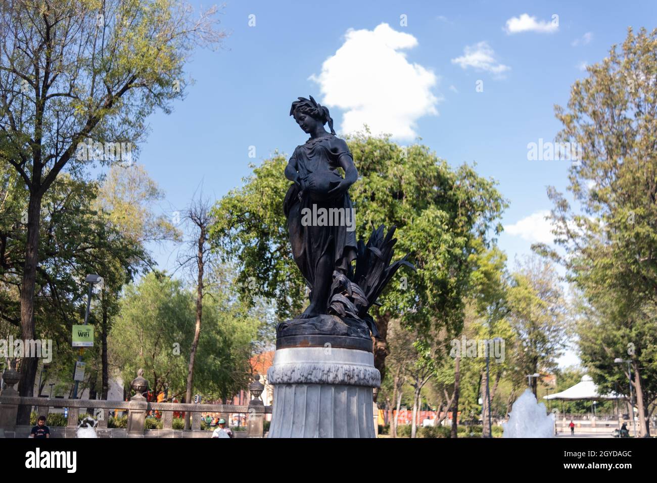 Beautiful statue of woman with trees and blue sky as background Stock ...