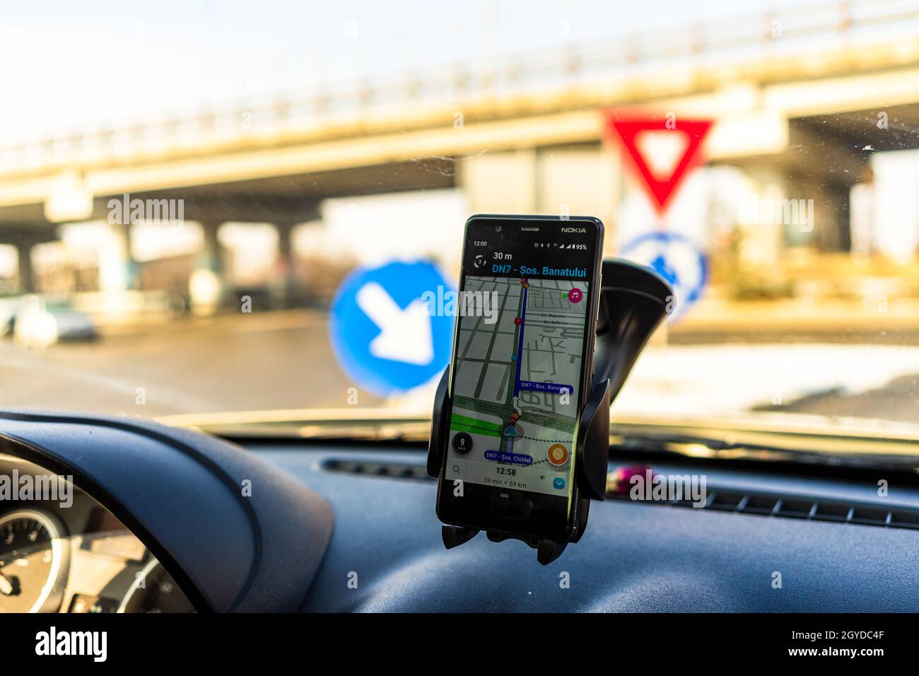 Using waze maps application on smartphone in car dashboard. Driver ...