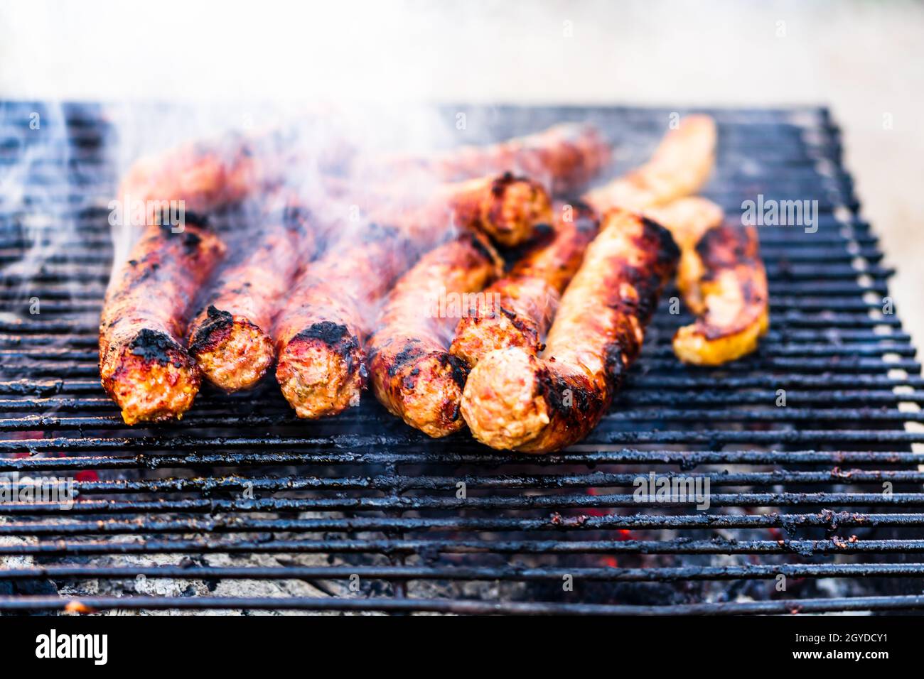 Grilling sausages on barbecue grill. Delicious sausages on charcoal ...