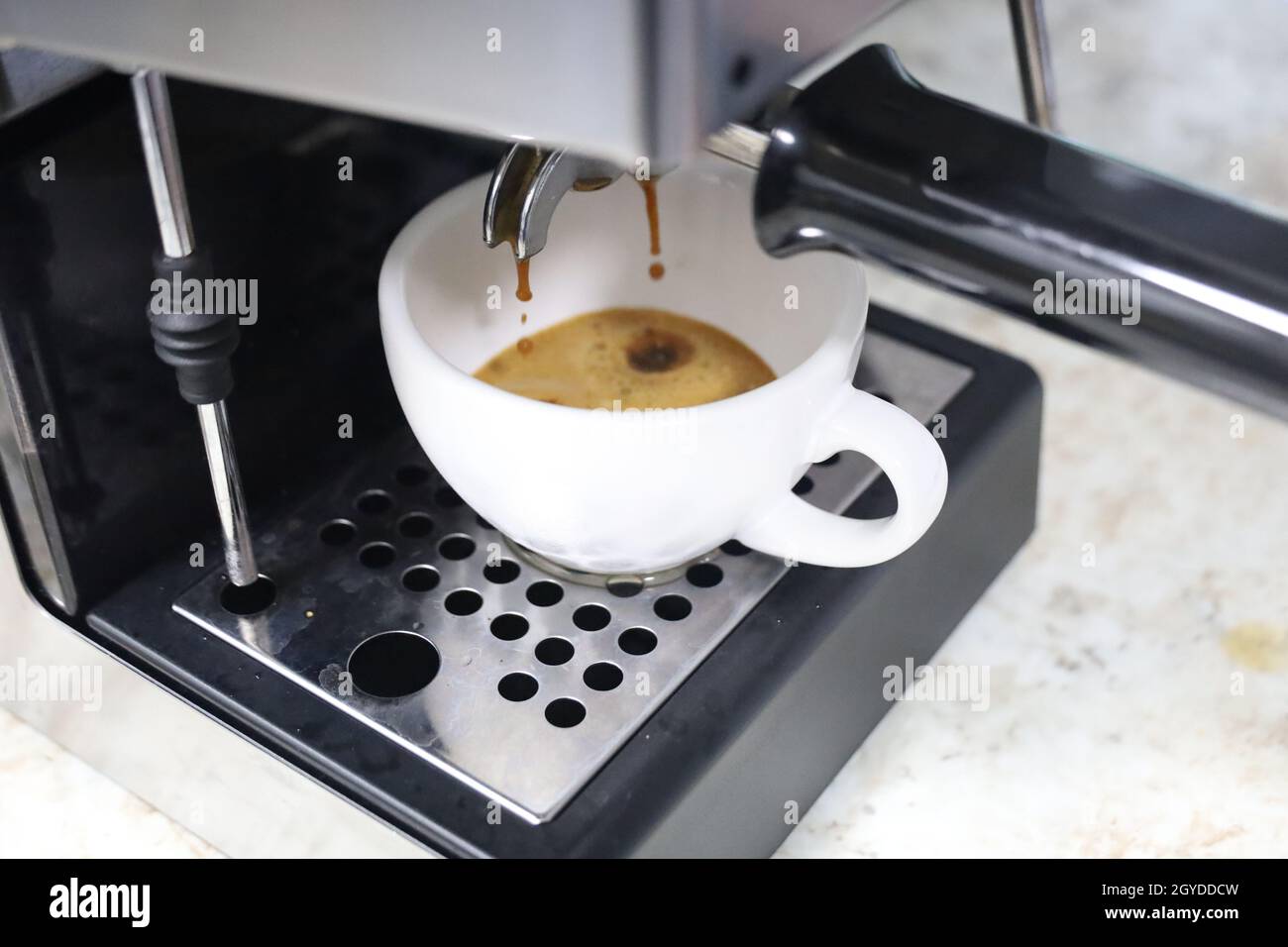 Closeup of coffee pouring from a coffee machine in a cup Stock Photo ...