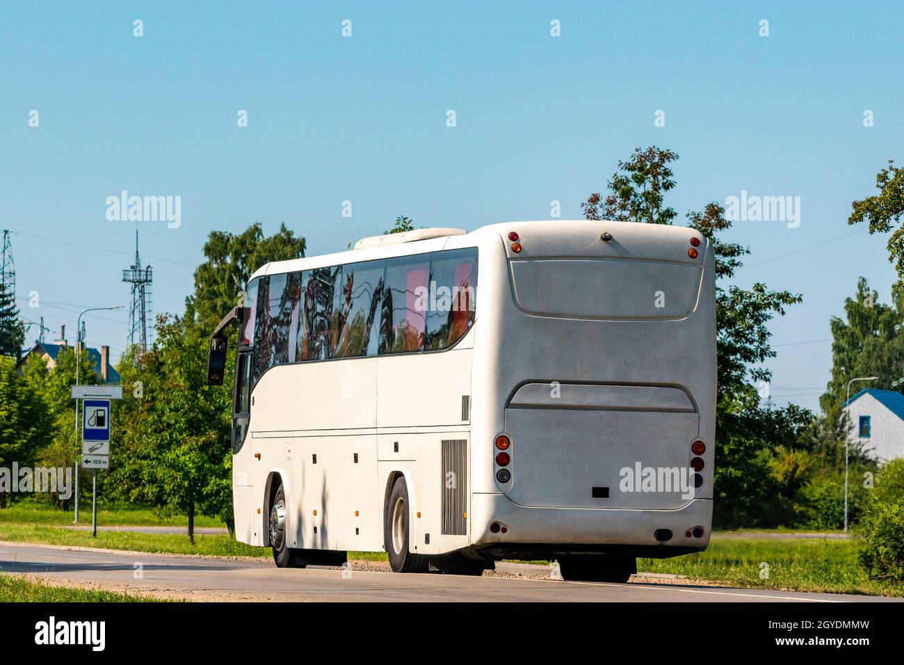 Rear view of white bus traveling on the road in a rural landscape Stock ...
