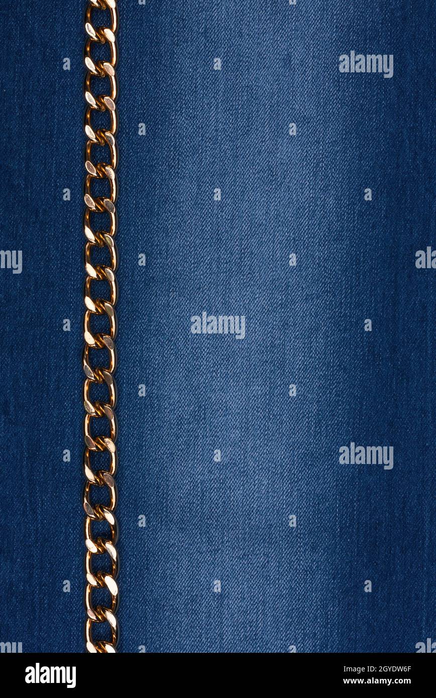 Gold chain lying on denim, can be used as background Stock Photo - Alamy