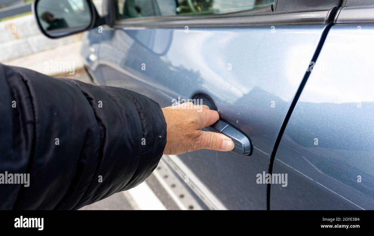arm with hand wielding the lock of a car door to open it Stock Photo ...