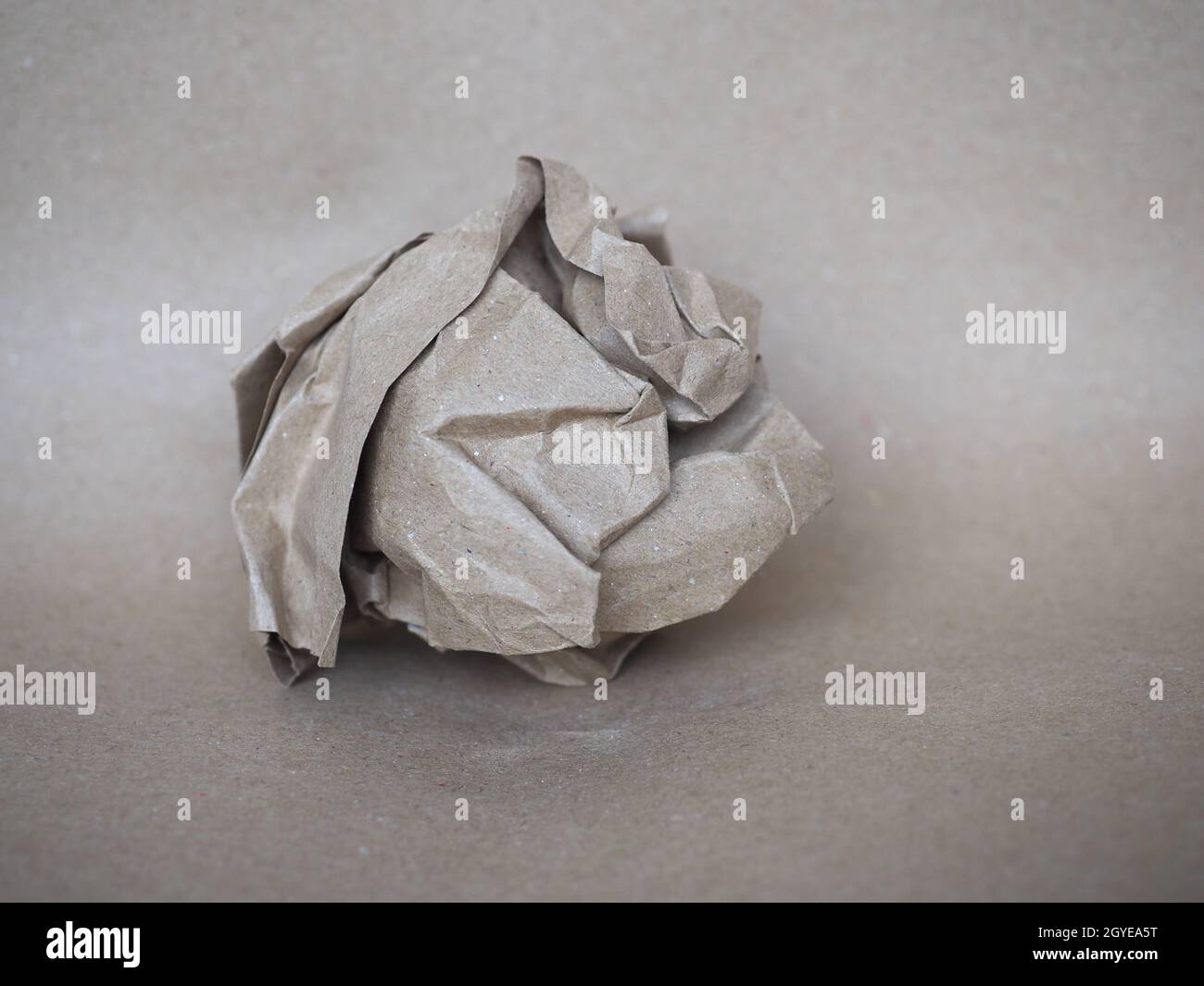 crumpled paper ball over brown paper background Stock Photo - Alamy