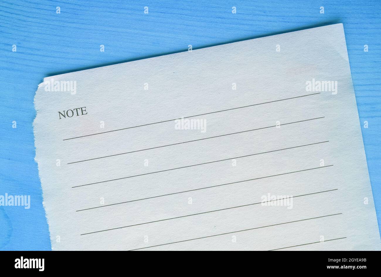 blank paper page of a notepad with copy space over blue wood desktop ...