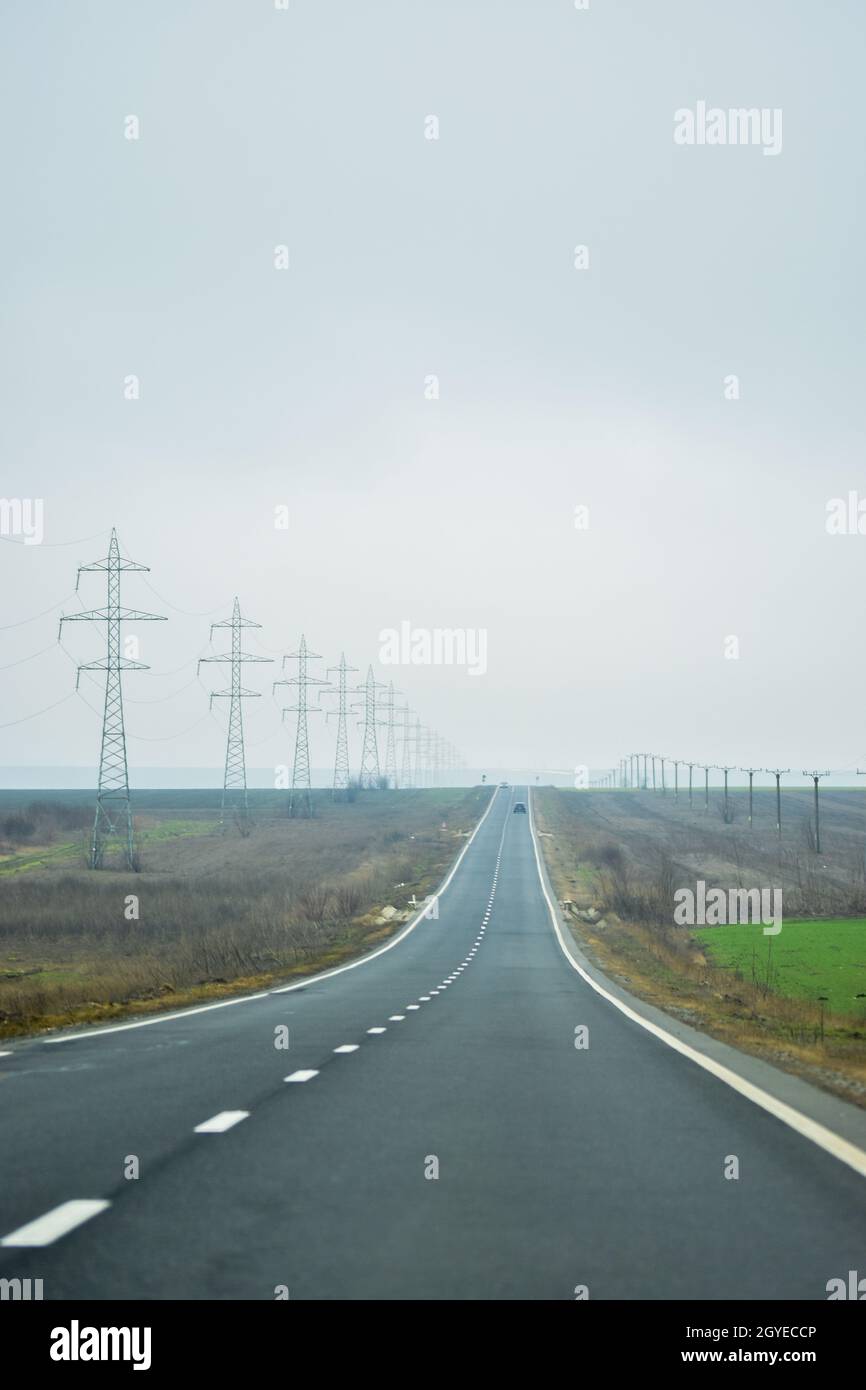 Smooth highway with rows of transmission towers on both sides Stock ...
