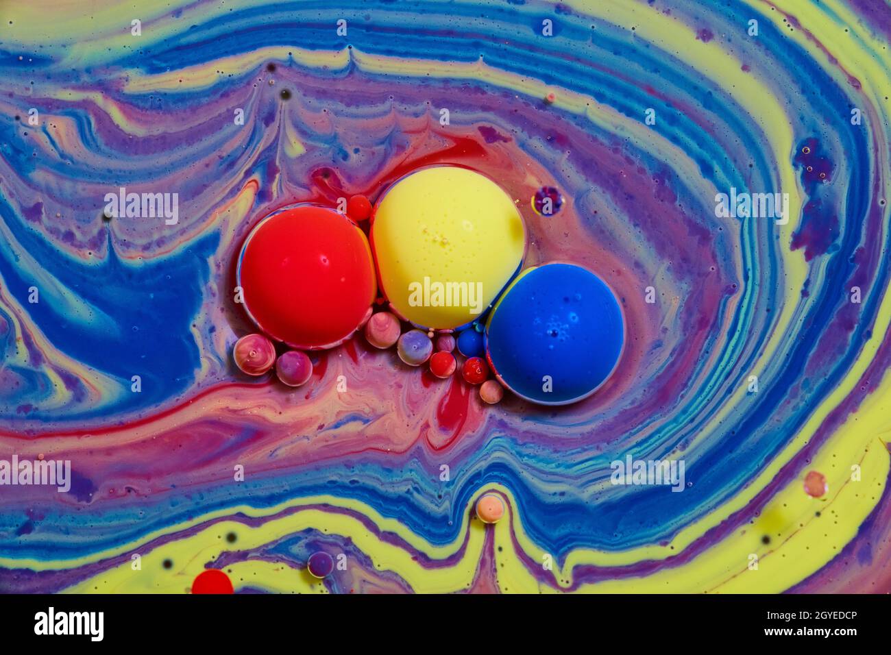 Red, yellow, and blue spheres on colorful rainbow surface Stock Photo ...