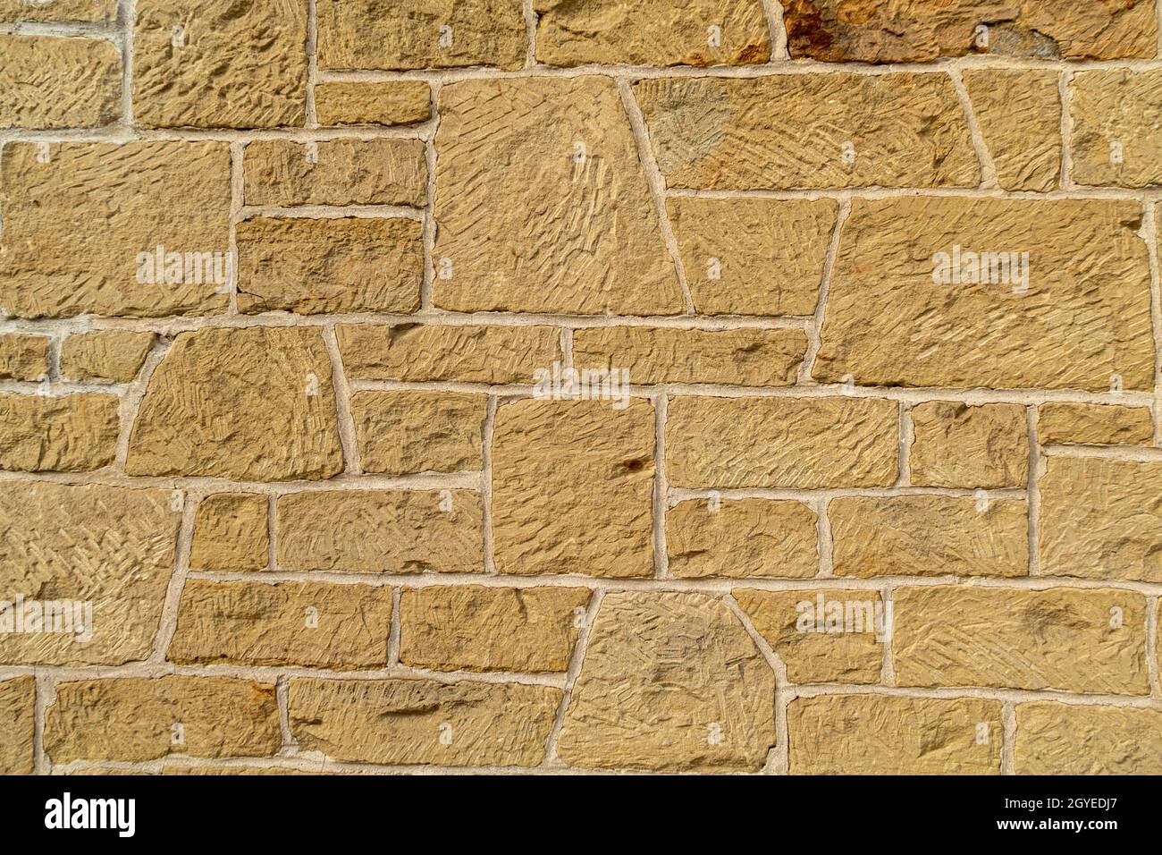 well maintained wall with irregularly sized naturally hewn yellow ...