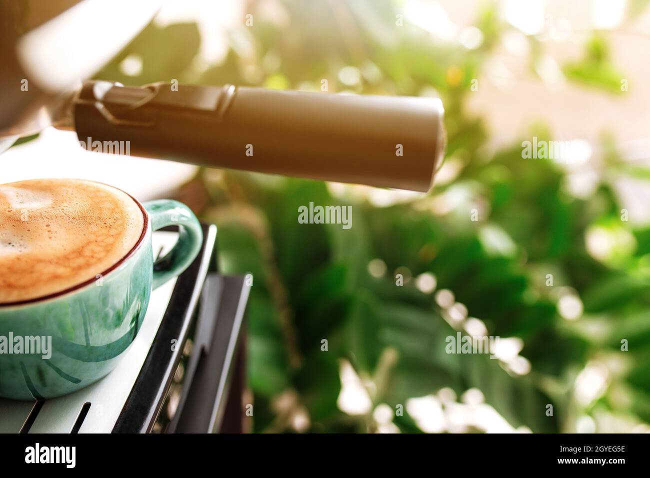 Green cup of coffee on coffee maker machine with dispenser. Mug full of ...