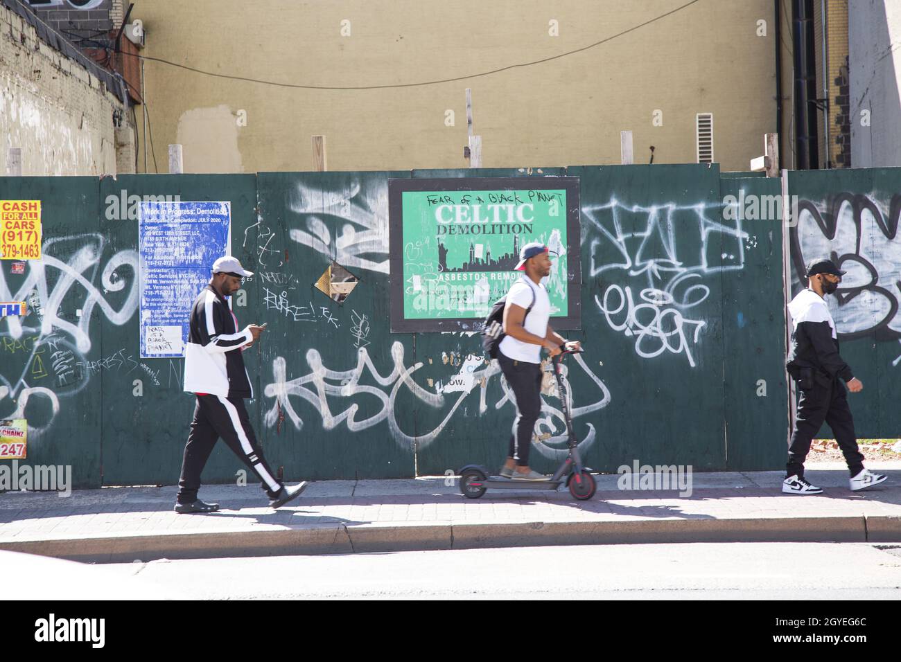 People walk past a construction site on 125th Street in the Harlem; NYC ...