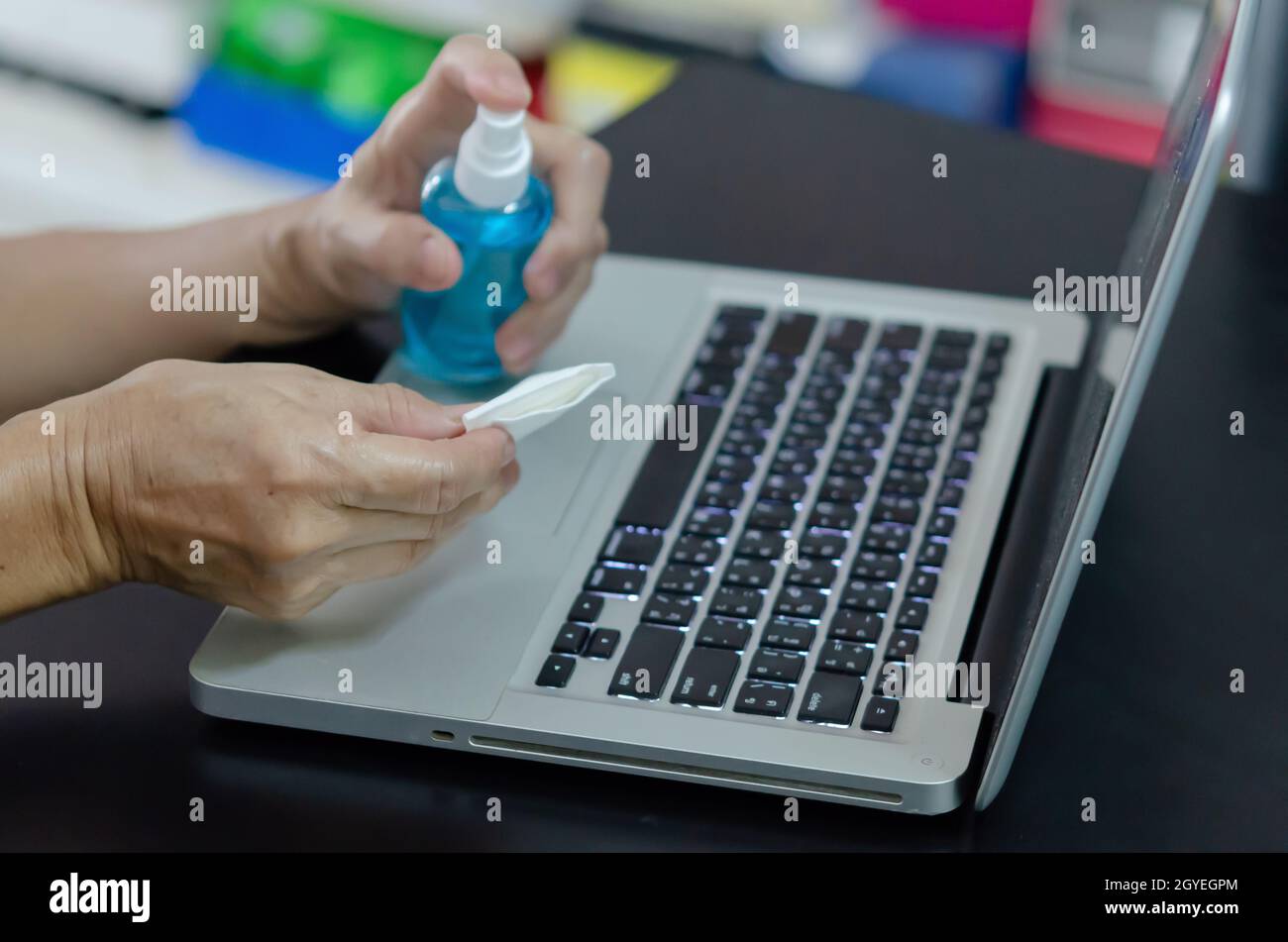 Spraying alcohol to clean the computer and wipe the germs. Health care ...