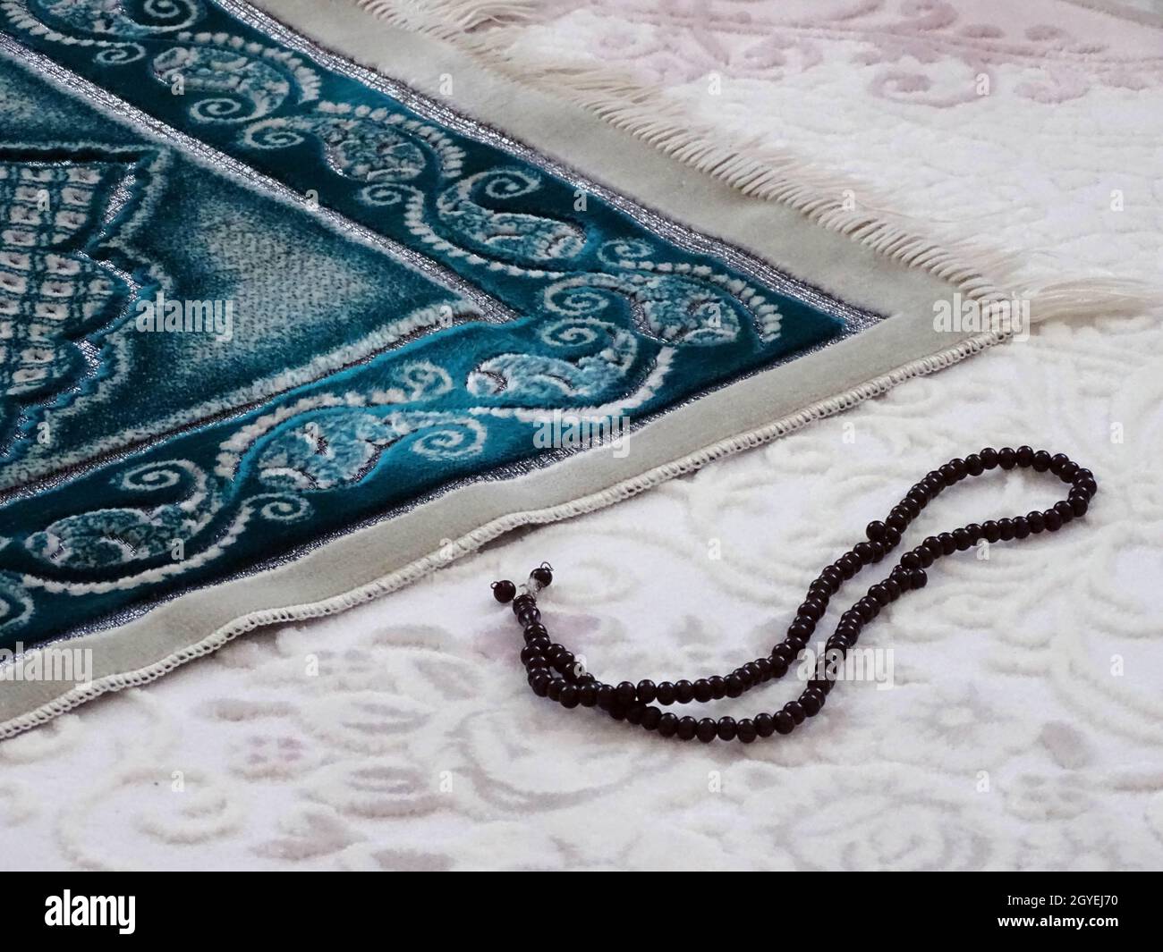 prayer mat and rosary laid on the ground for worship, prayer rug in ...