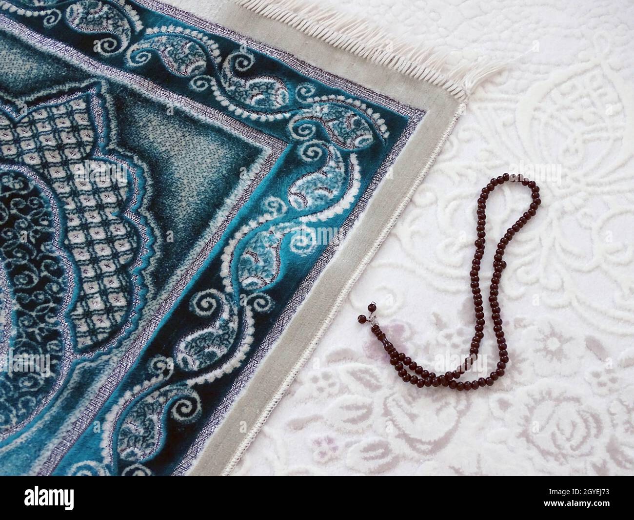 prayer mat and rosary laid on the ground for worship, prayer rug in ...